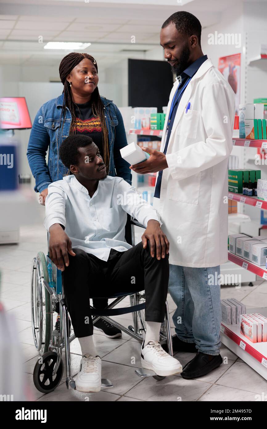 African american pharmacy consultant helping man with disability ...