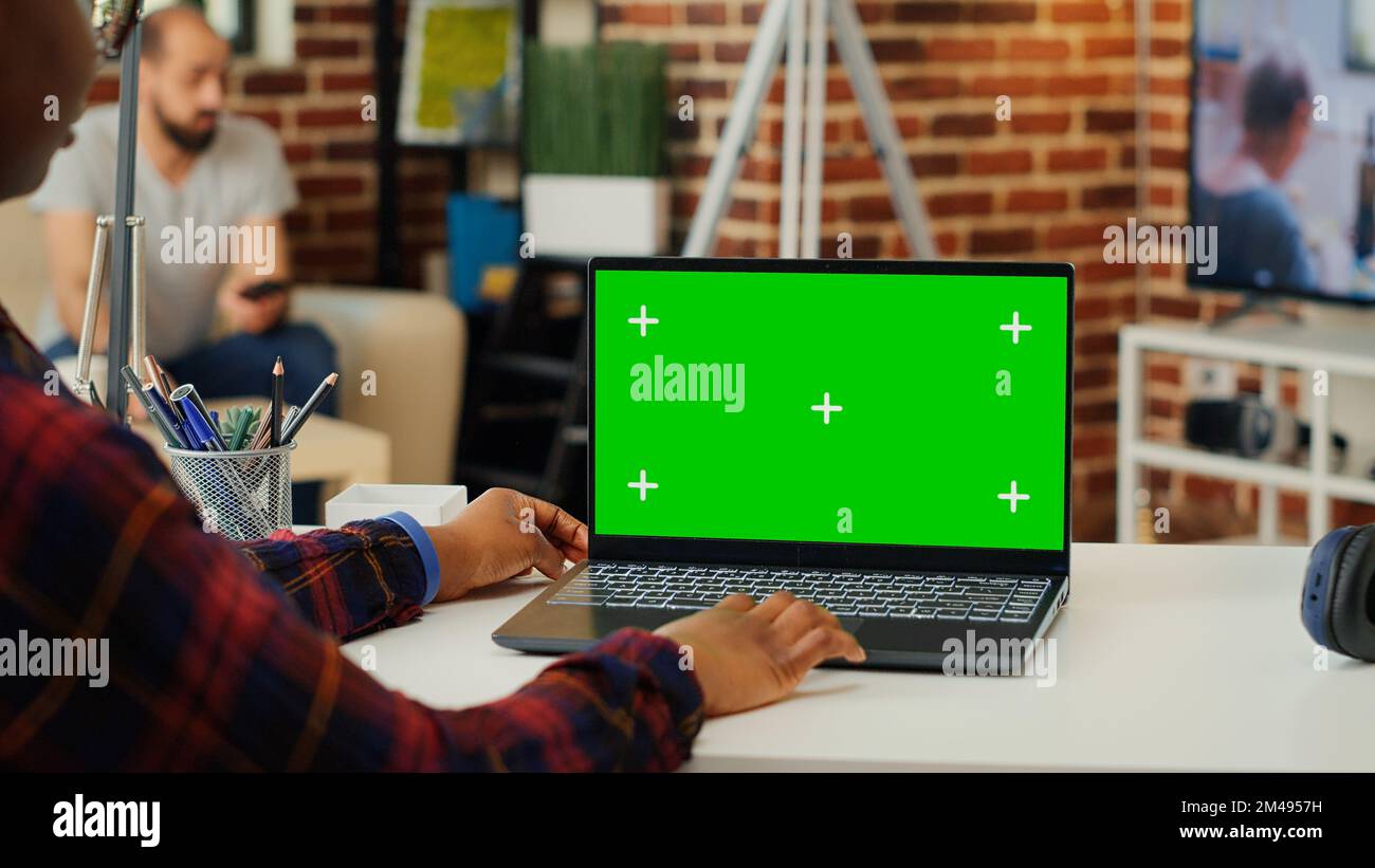 Office entrepreneur looking at greenscreen display on laptop, using ...