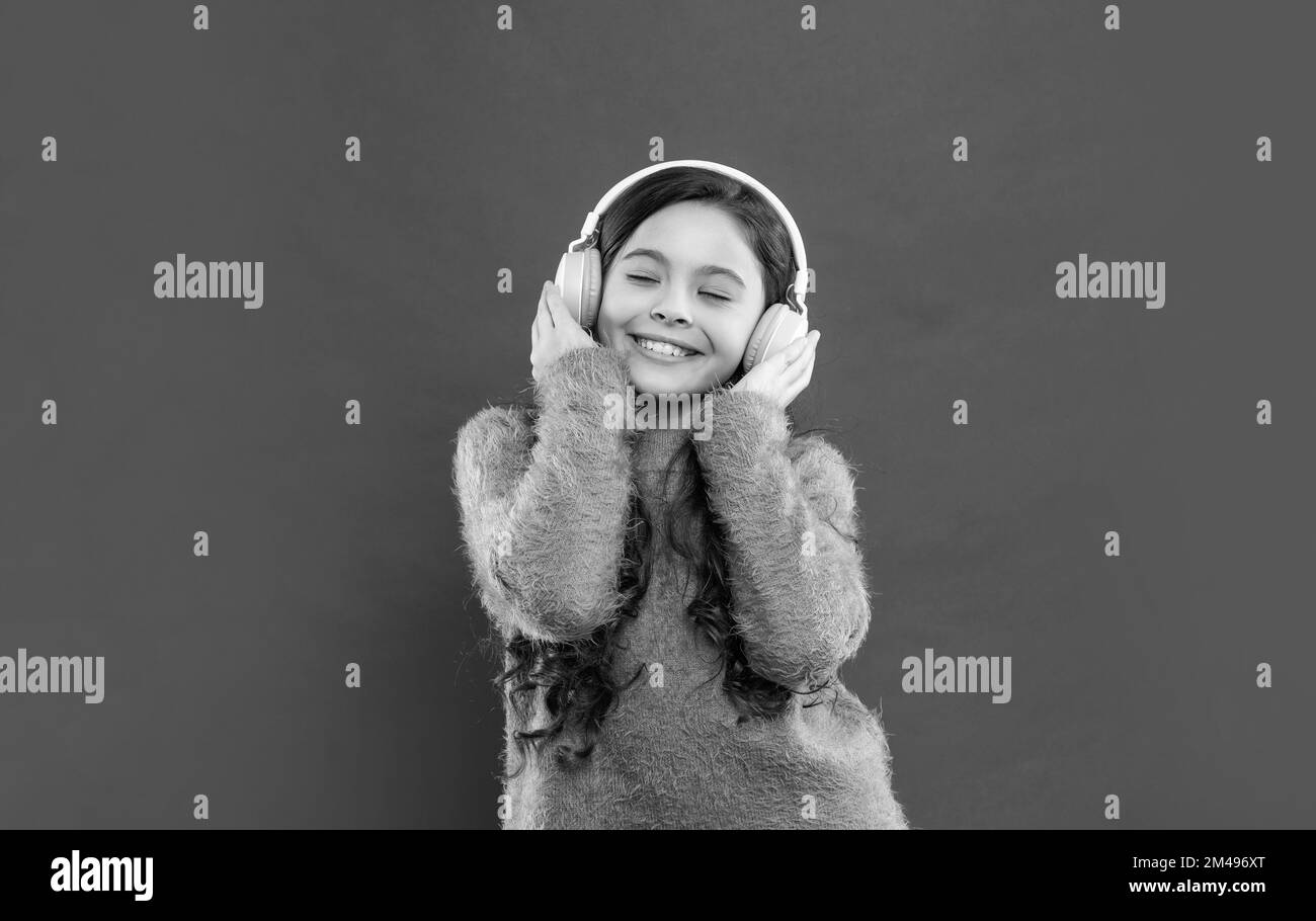 happy kid in sweater listen music in earphones, childhood Stock Photo ...