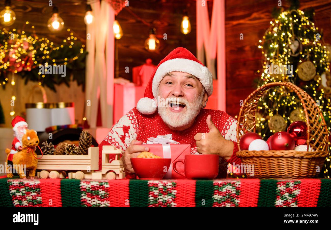 New year. Joyful grandpa with gift. Dreamy grandfather in Santa hat ...