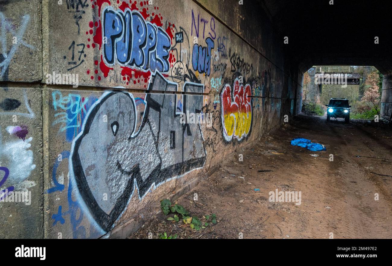Wall graffiti and fly tipping inside an abandoned road tunnel Stock ...