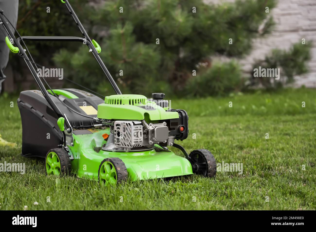 Modern lawn mower on green grass Stock Photo - Alamy