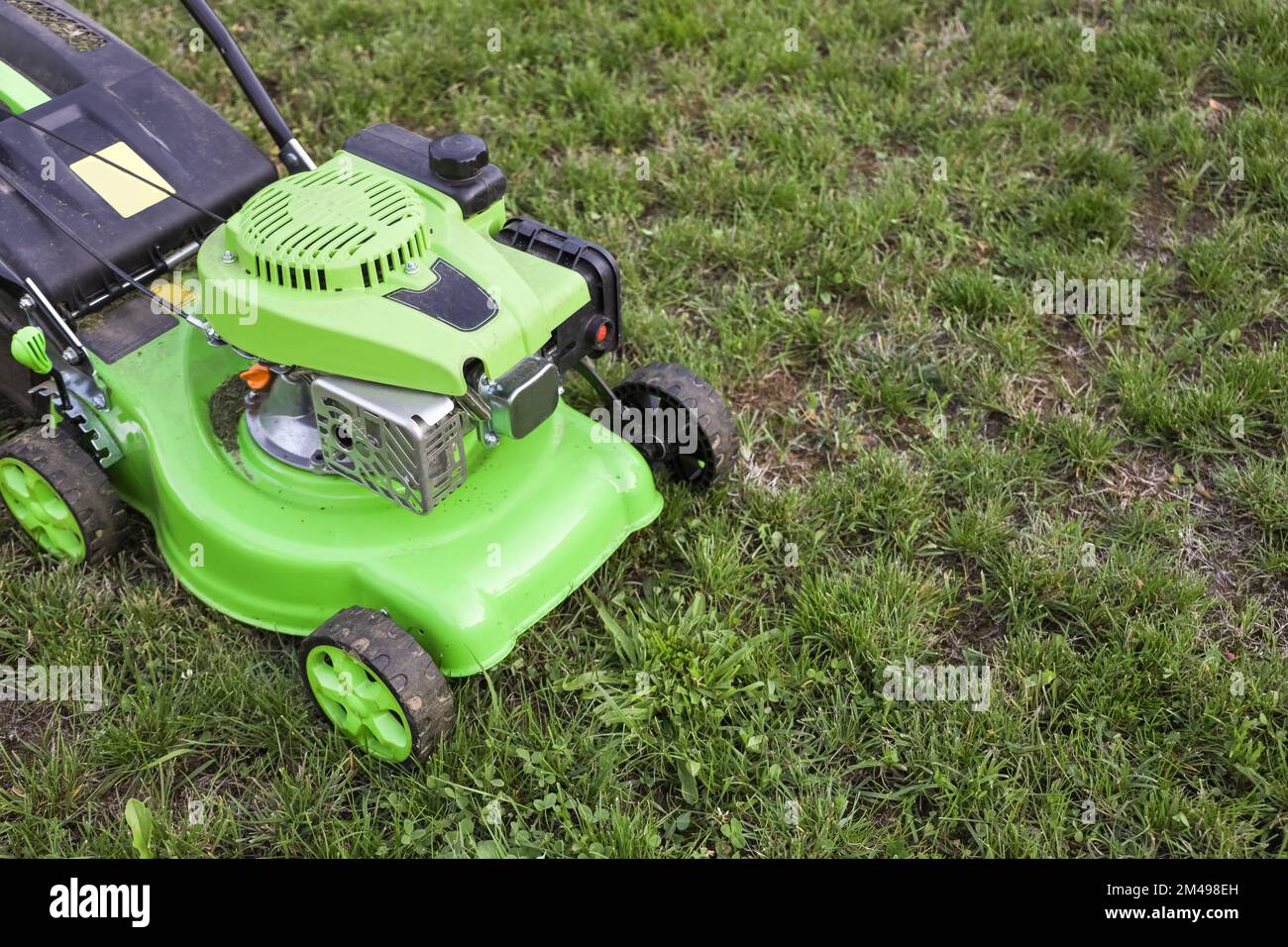 Modern lawn mower on fresh green grass Stock Photo - Alamy