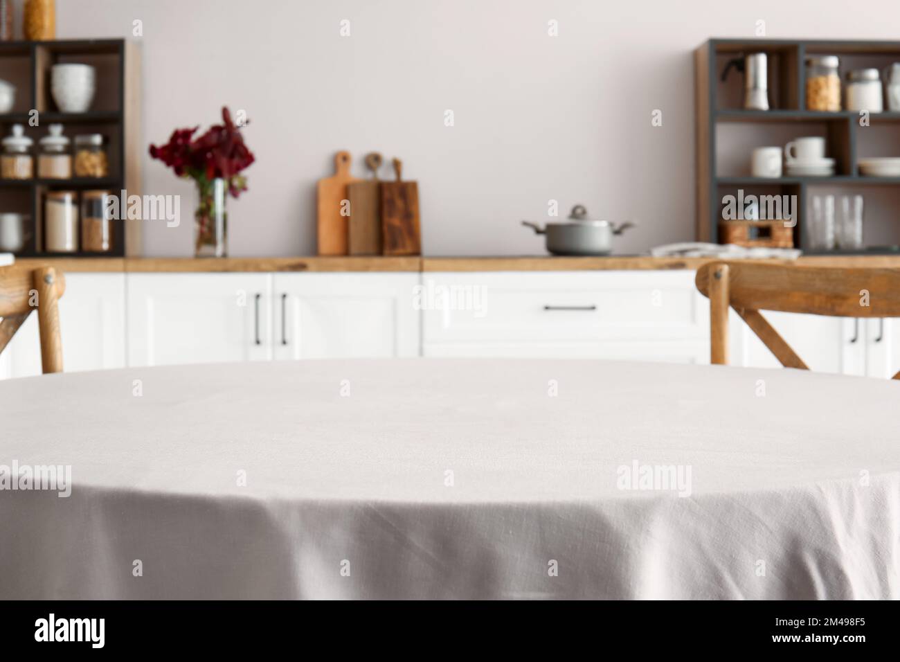 Empty dining table in light kitchen Stock Photo - Alamy