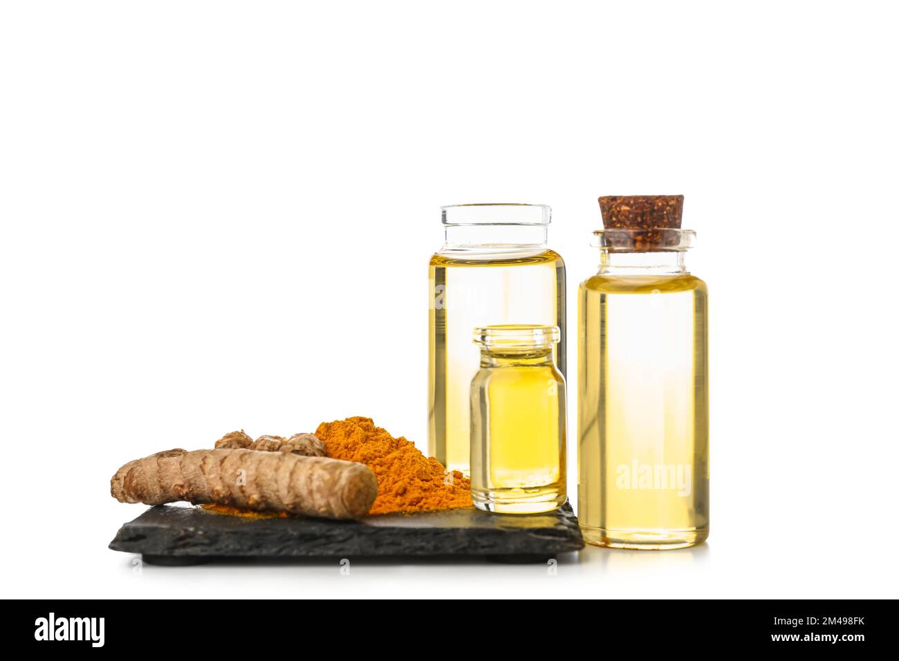 Bottles of essential turmeric oil, powder and root on white background ...