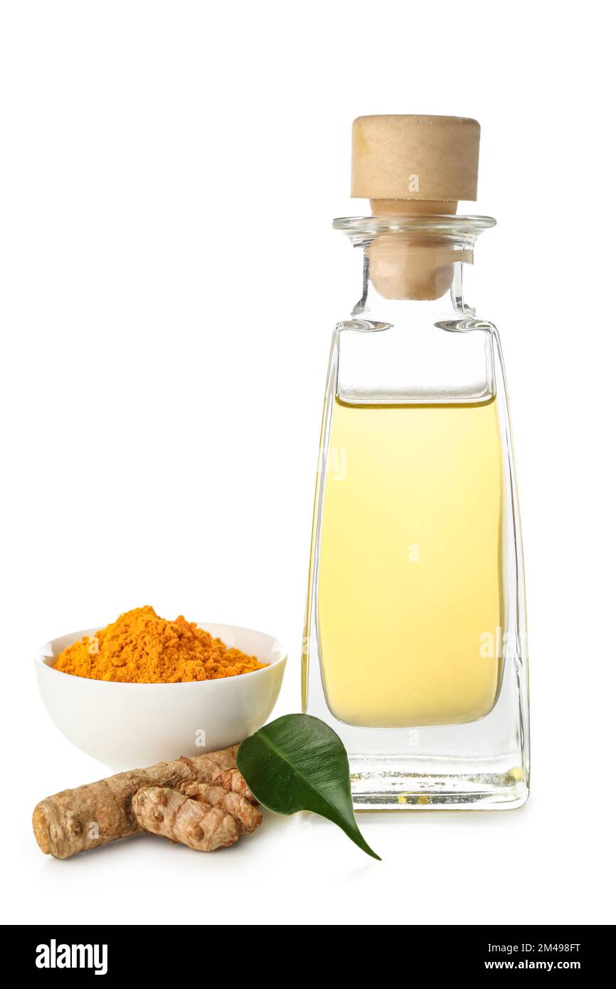 Bottle of essential turmeric oil, powder and root on white background ...