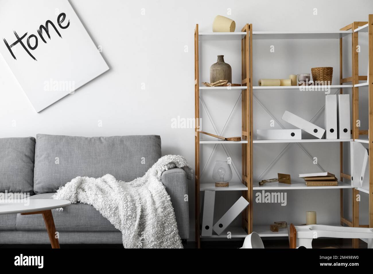 Interior of messy living room with grey sofa and shelving unit Stock ...