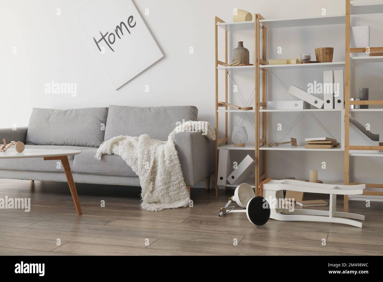 Interior of messy living room with grey sofa and shelving unit Stock ...