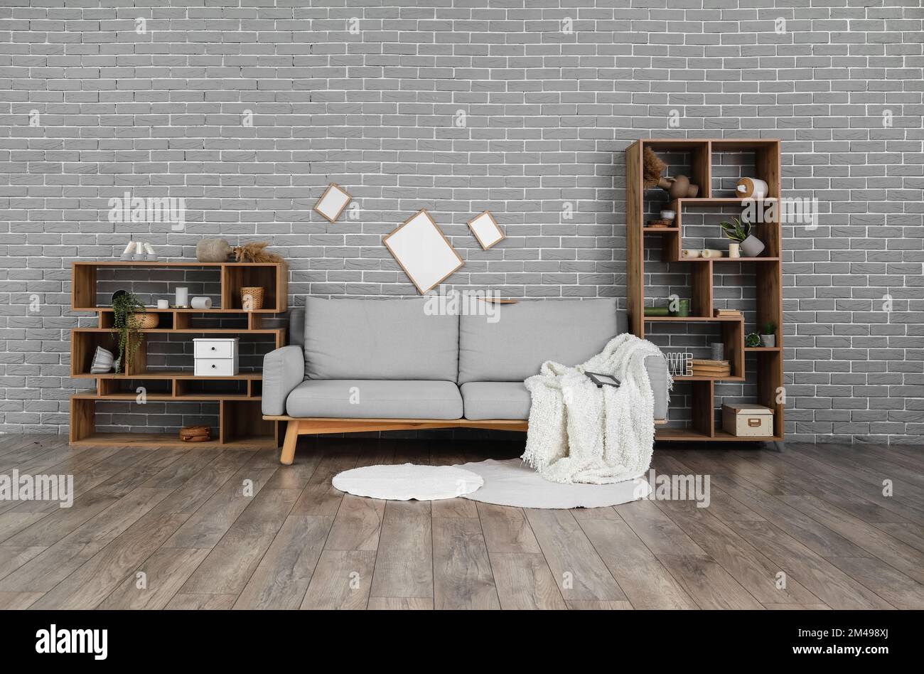 Interior of messy living room with sofa, shelf units and blank photo ...
