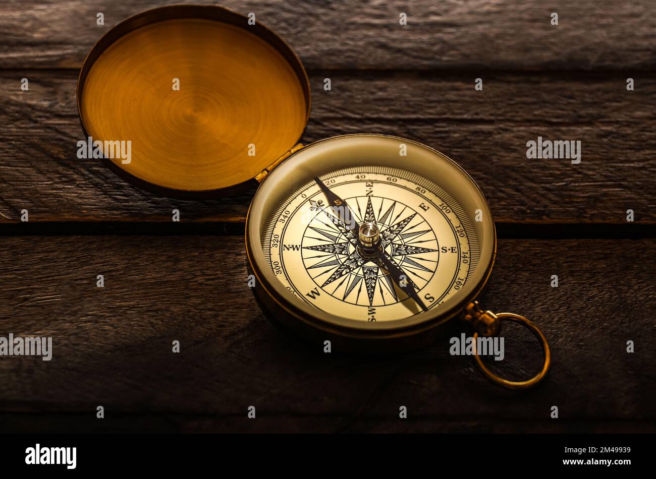 Golden compass on dark wooden background Stock Photo - Alamy