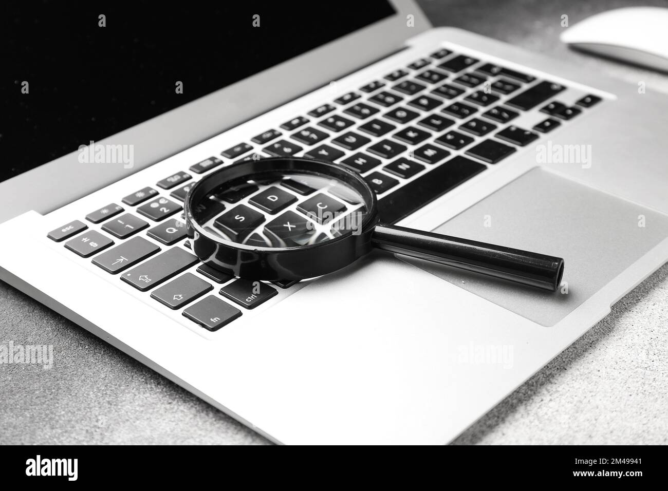 Laptop and magnifying glass on table, closeup. Internet search concept ...