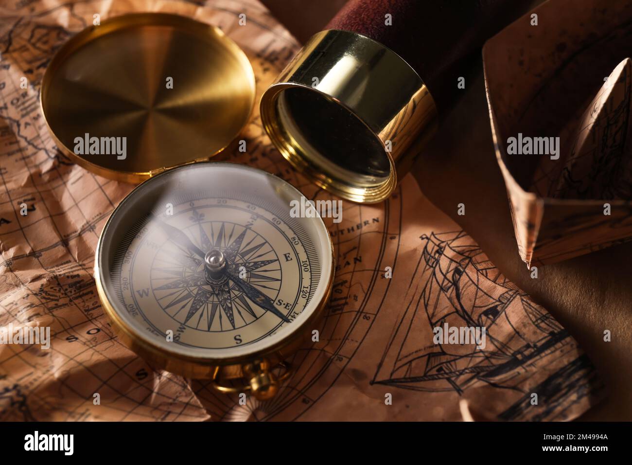 Golden compass with spyglass on world map, closeup Stock Photo - Alamy