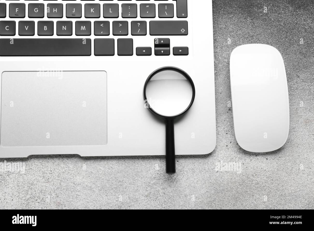 Laptop, computer mouse and magnifier on table. Internet search concept ...
