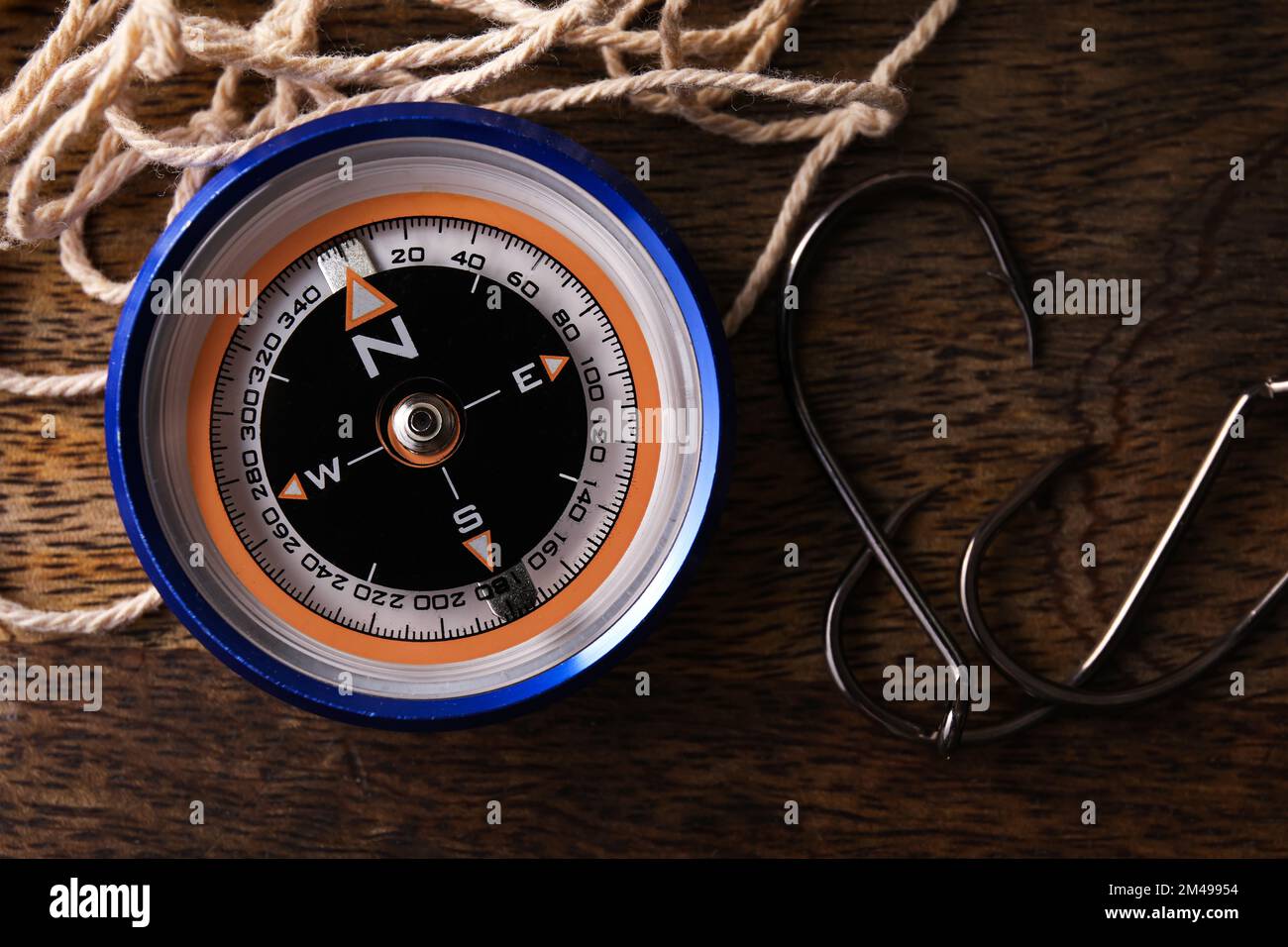 Compass with hooks and net on dark wooden background Stock Photo - Alamy