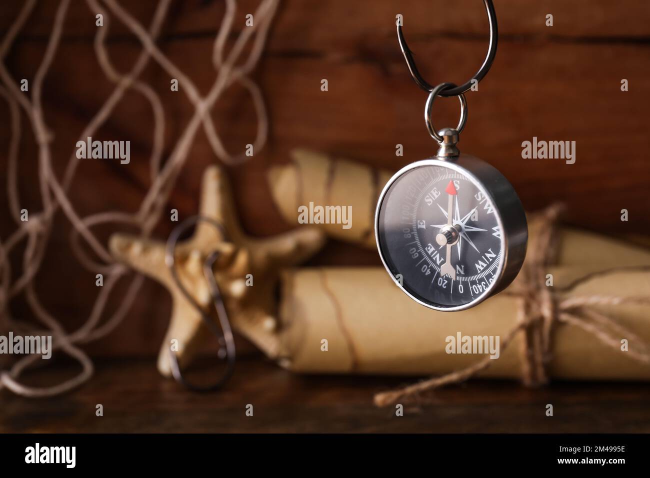 Compass hanging on wooden background, closeup Stock Photo - Alamy