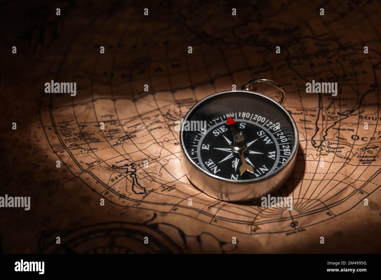 Small compass on world map Stock Photo - Alamy
