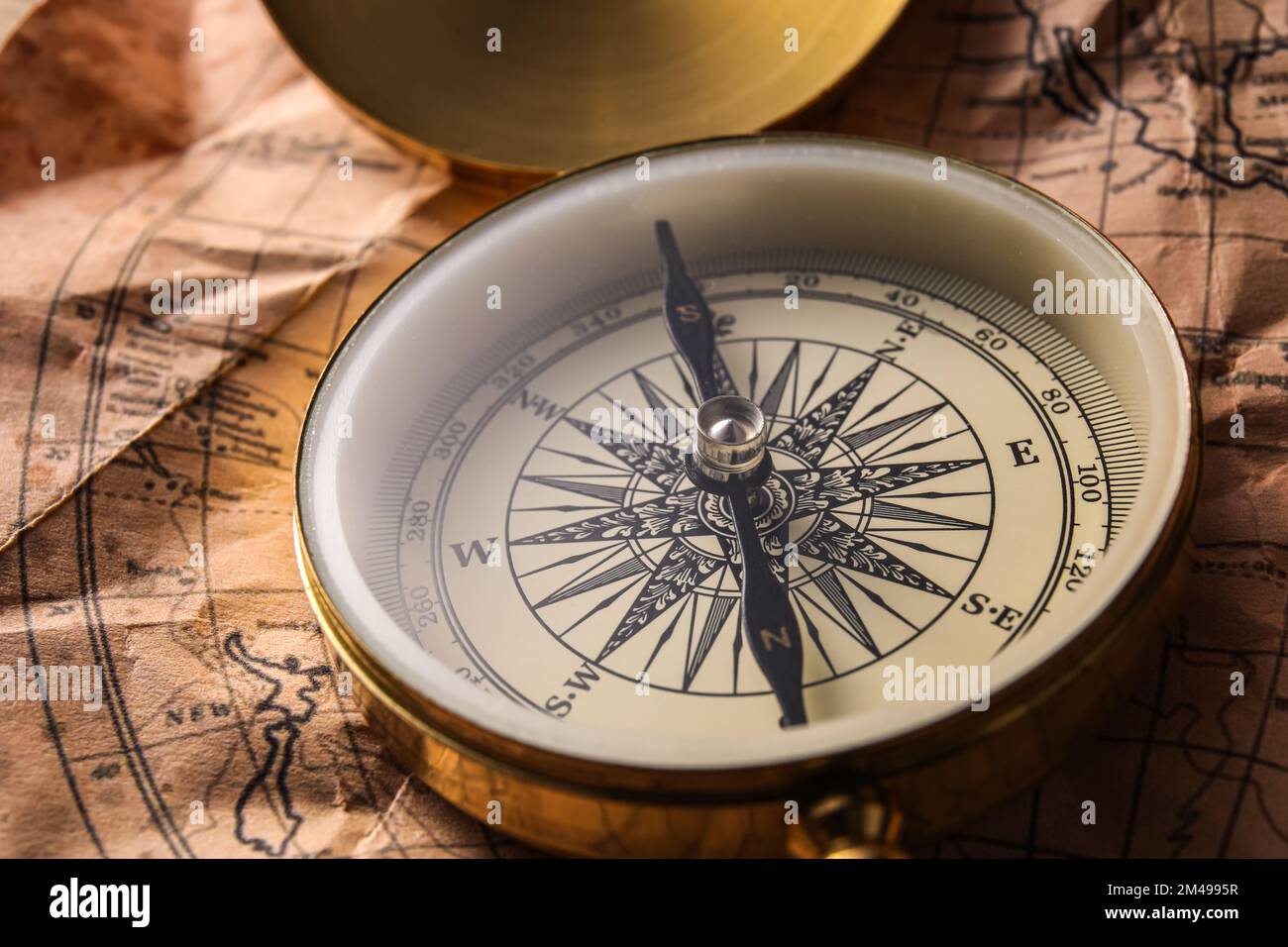 Golden compass on world map, closeup Stock Photo - Alamy