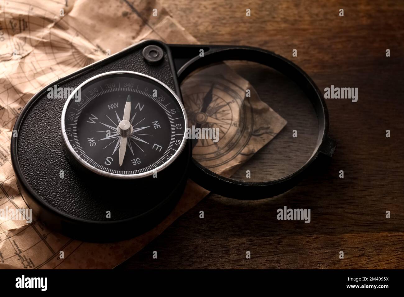 Compass and magnifier on world map Stock Photo - Alamy