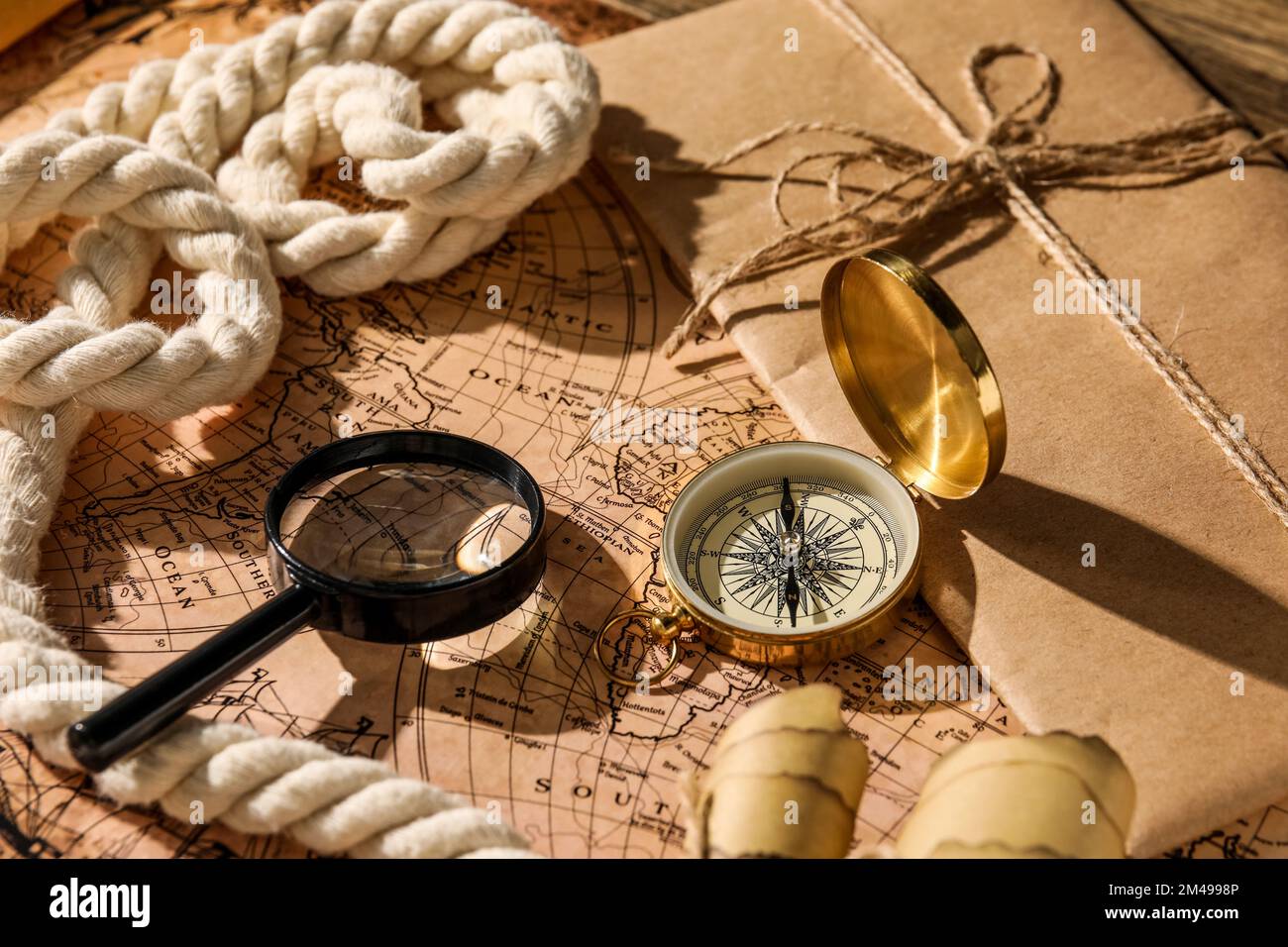Golden compass, magnifier and envelope on world map Stock Photo - Alamy
