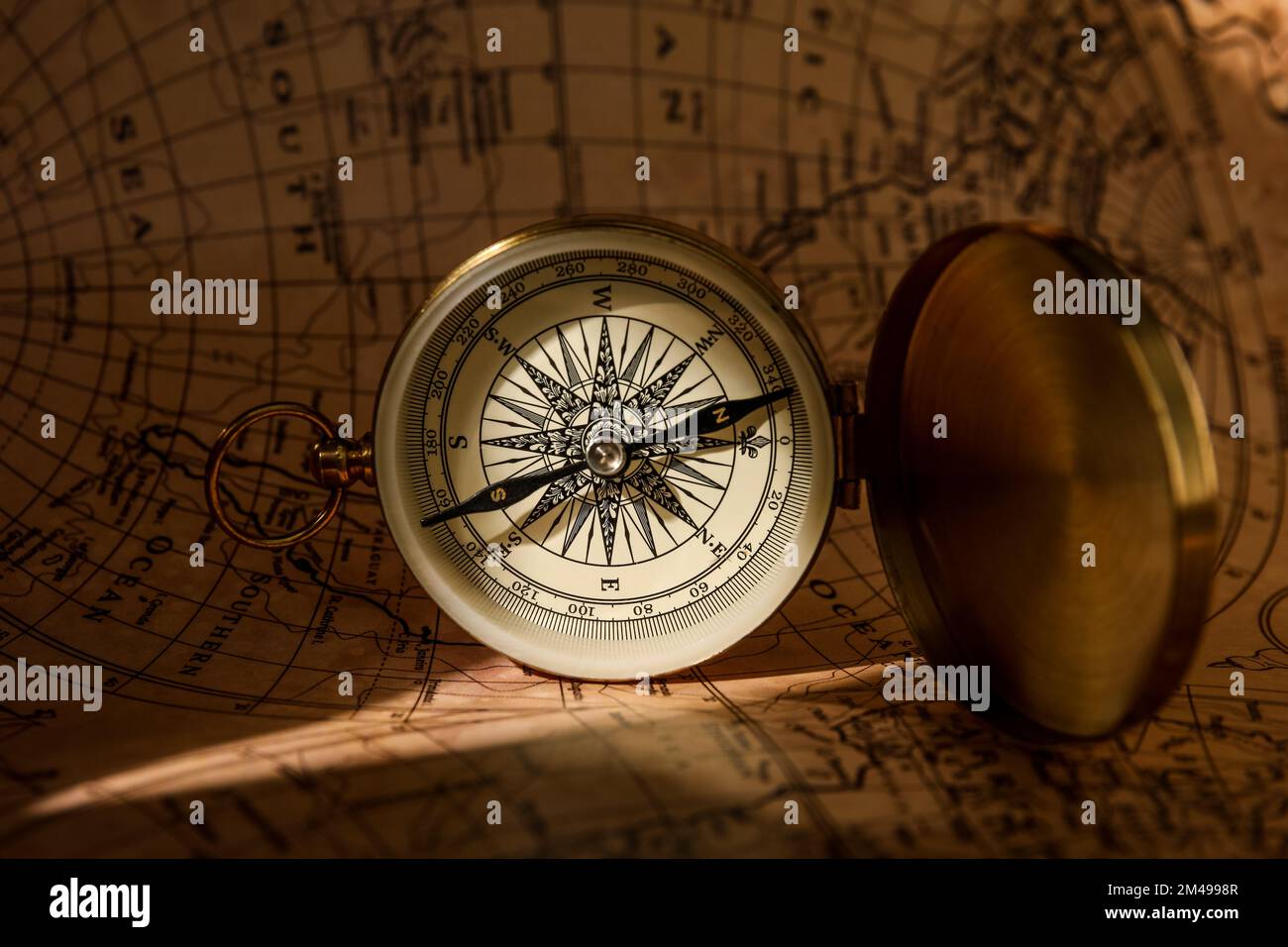 Golden compass on world map, closeup Stock Photo - Alamy