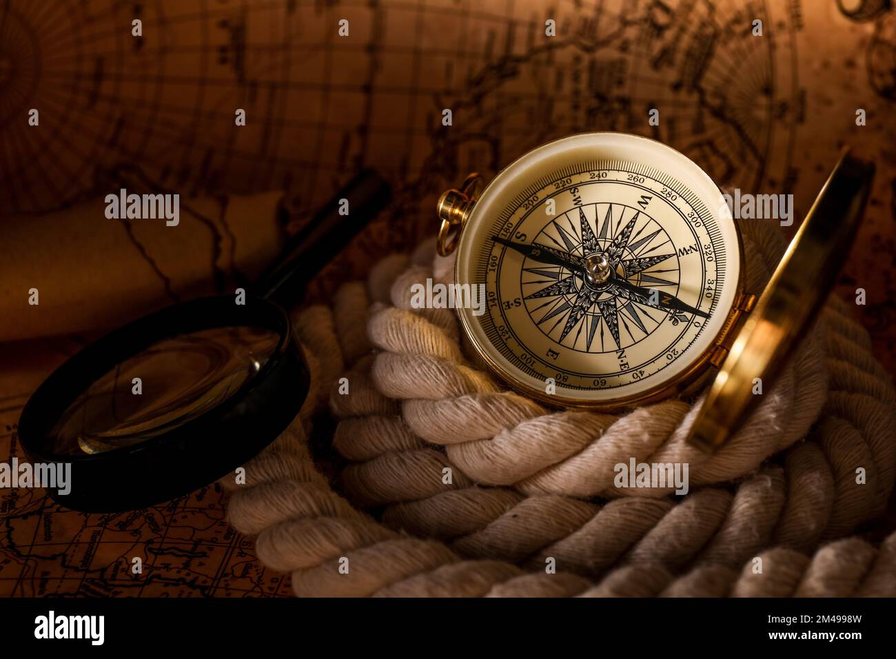 Vintage compass, magnifier and rope on world map Stock Photo - Alamy