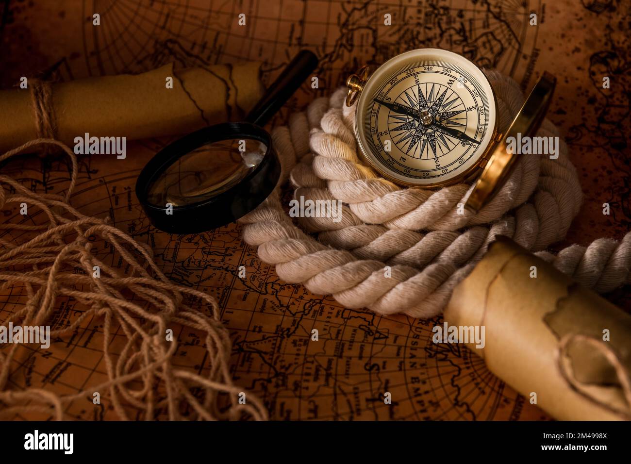 Vintage compass, magnifier and rope on world map Stock Photo - Alamy