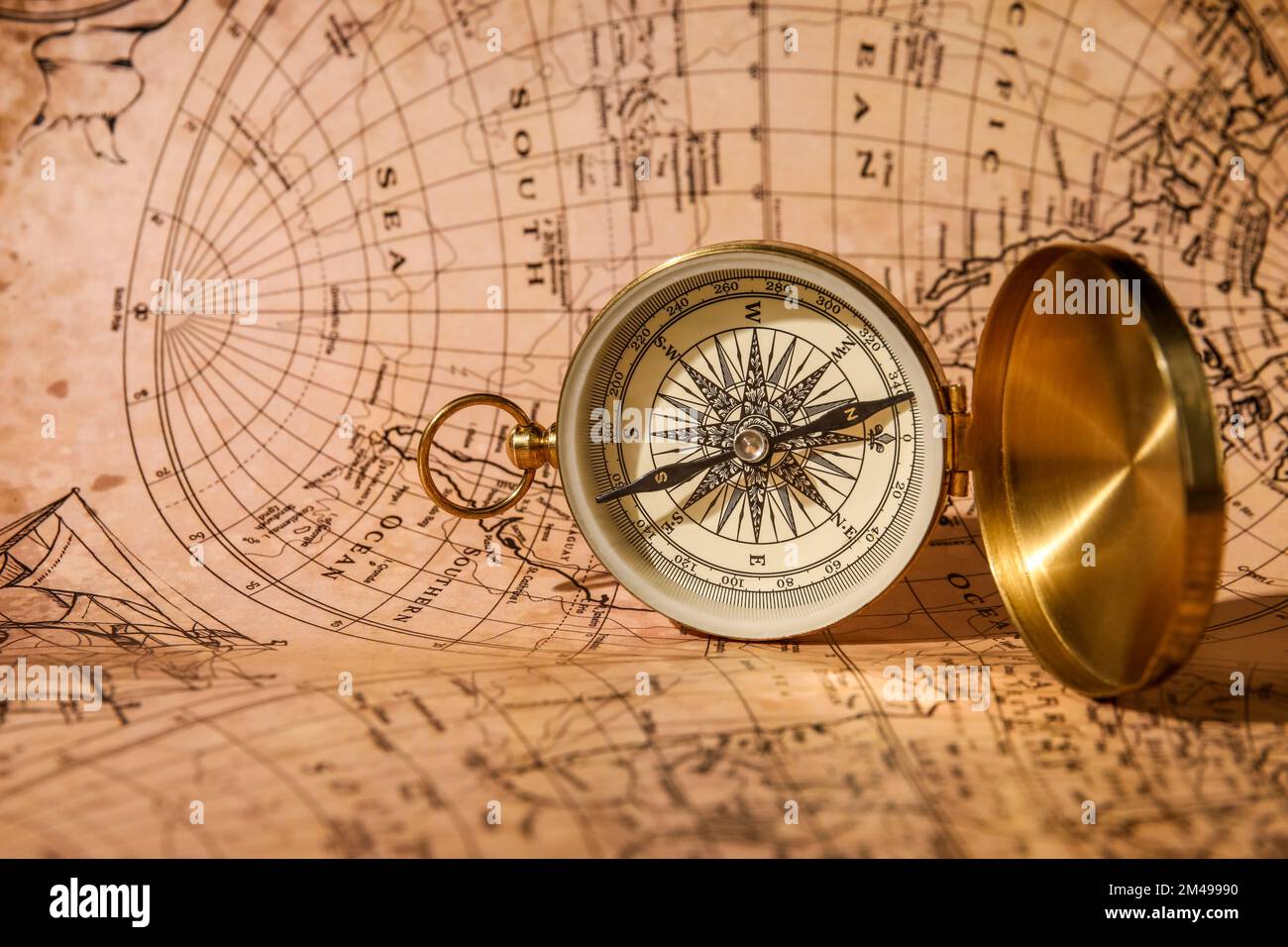 Golden compass on world map, closeup Stock Photo - Alamy