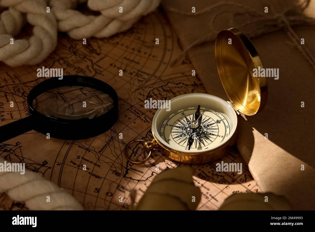 Golden compass, magnifier and envelope on world map Stock Photo - Alamy
