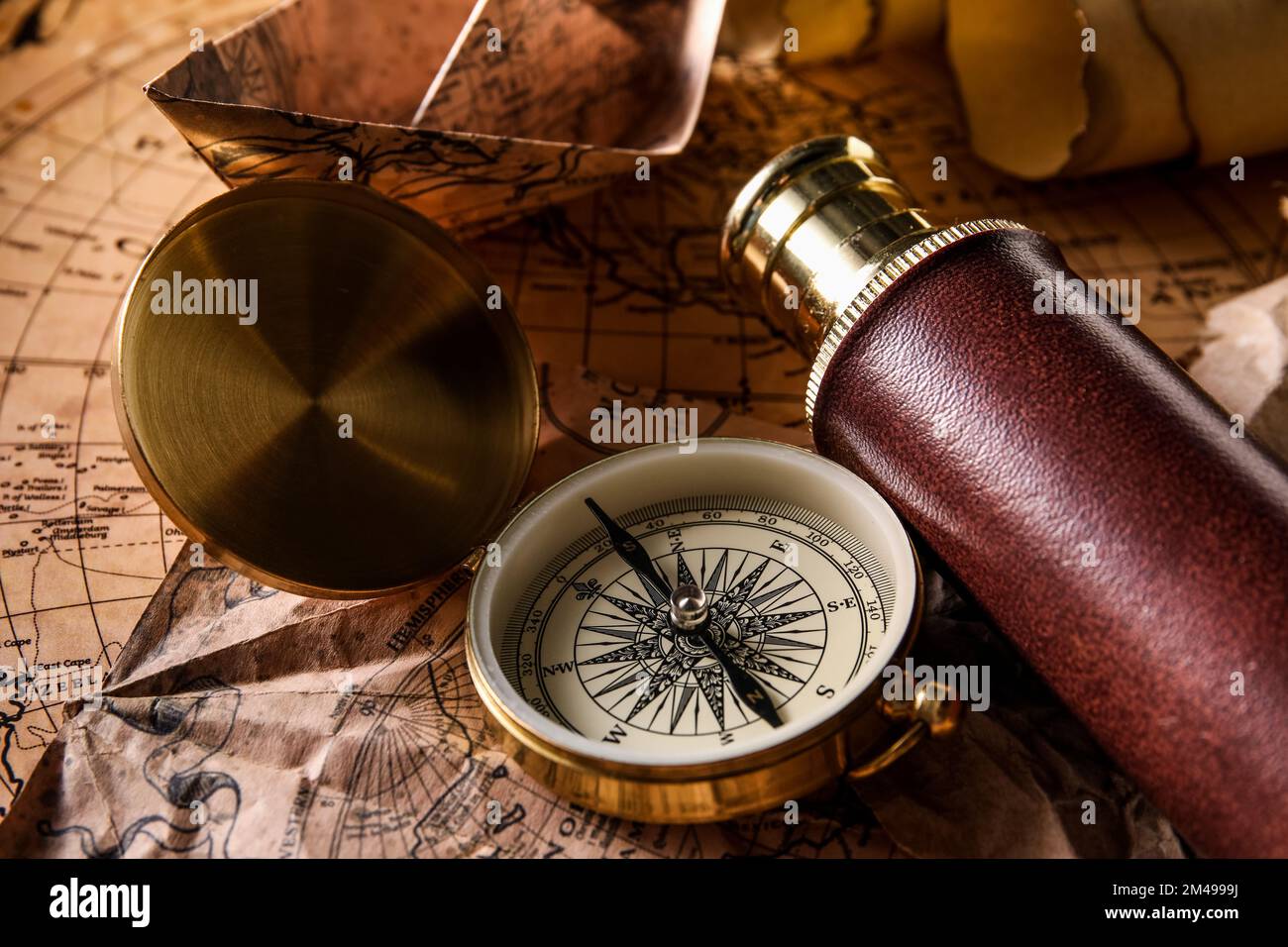 Compass and spyglass on world map, closeup Stock Photo - Alamy