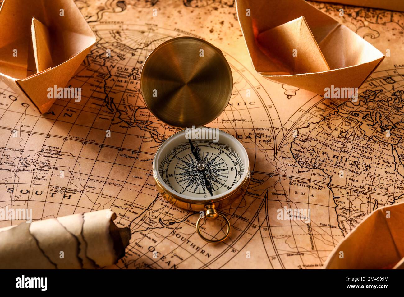 Vintage compass and paper boats on world map, closeup Stock Photo - Alamy