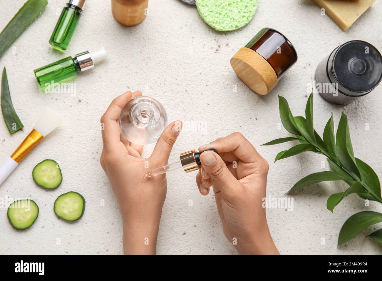 Woman applying essential oil onto hand on light background Stock Photo ...