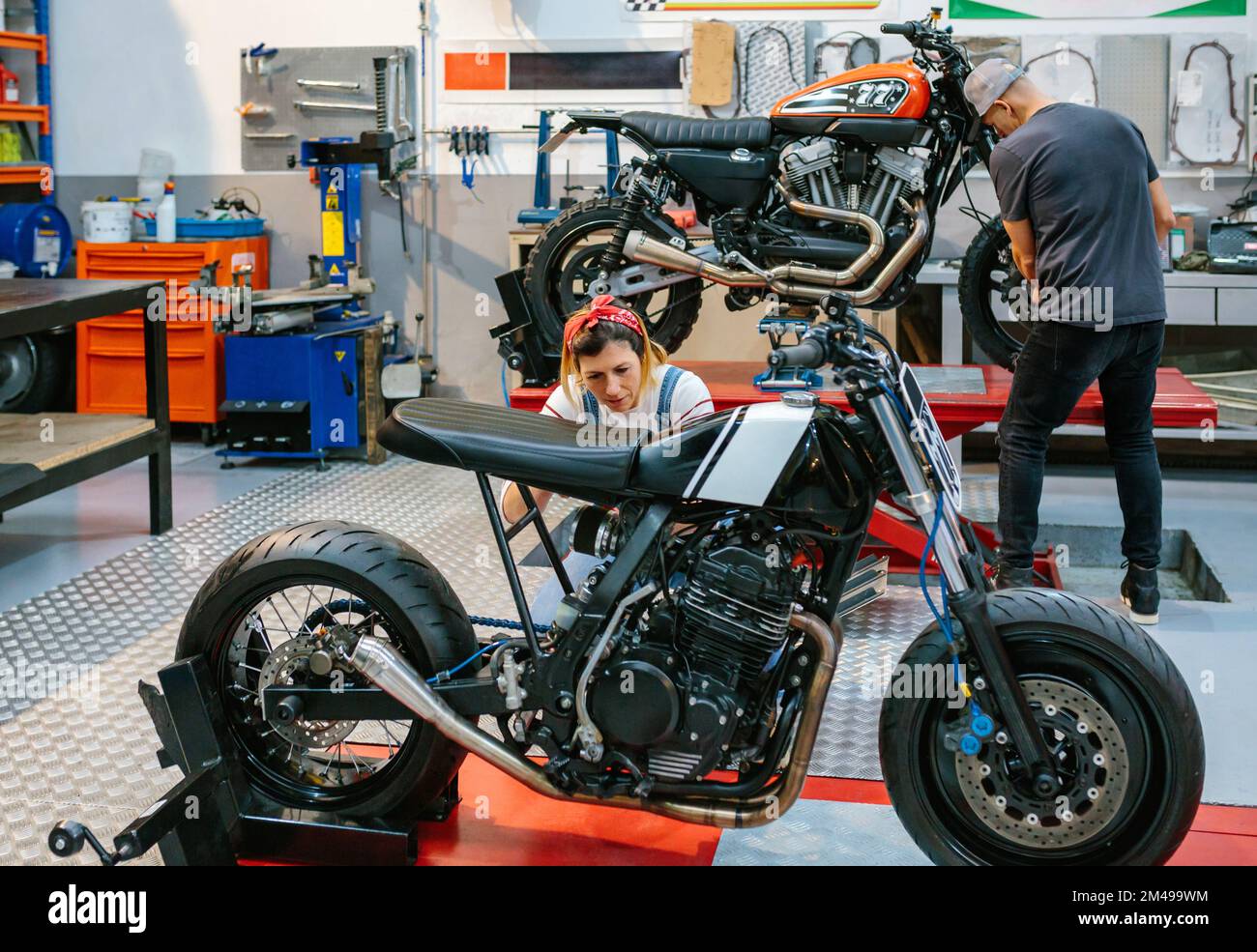 Mechanic checking custom motorcycle on garage Stock Photo - Alamy