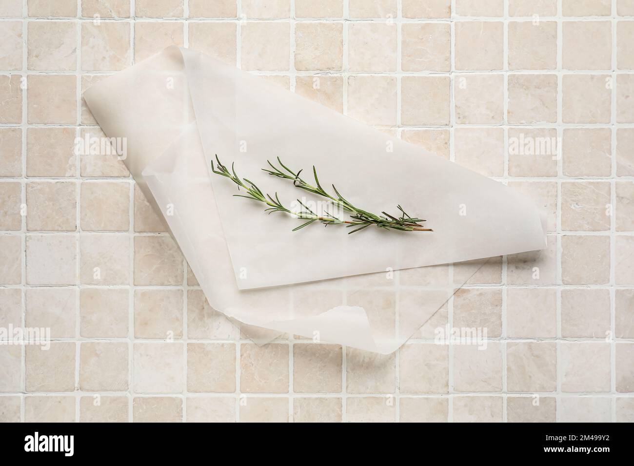 Baking paper with rosemary on beige tile background Stock Photo - Alamy