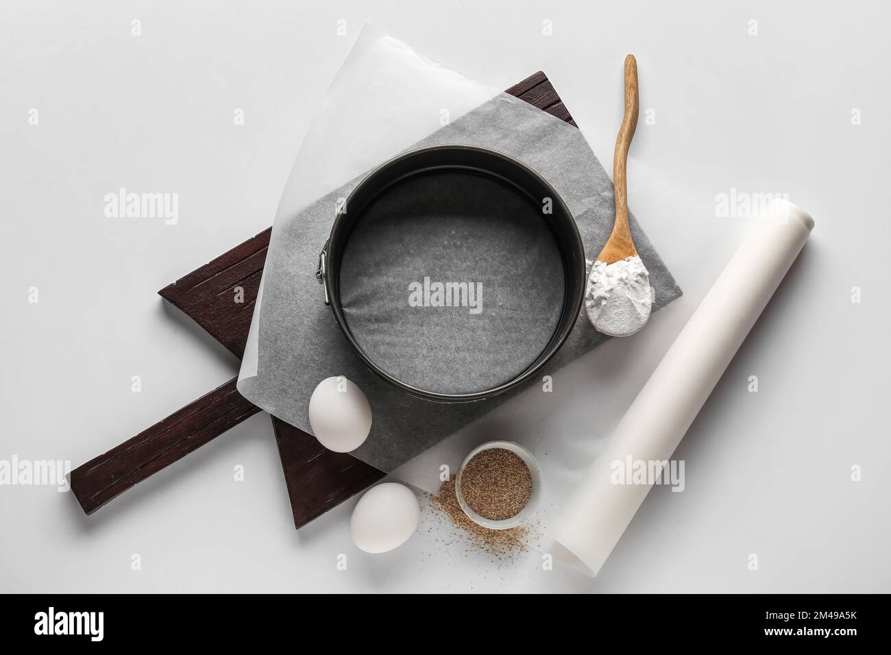 Baking paper with kitchen supplies and ingredients on white background ...