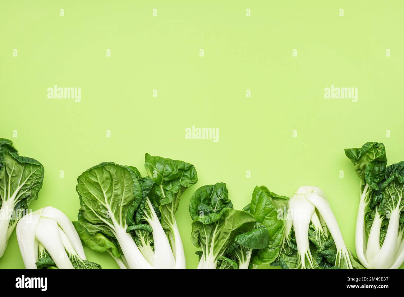 Fresh pak choi cabbages on green background Stock Photo - Alamy