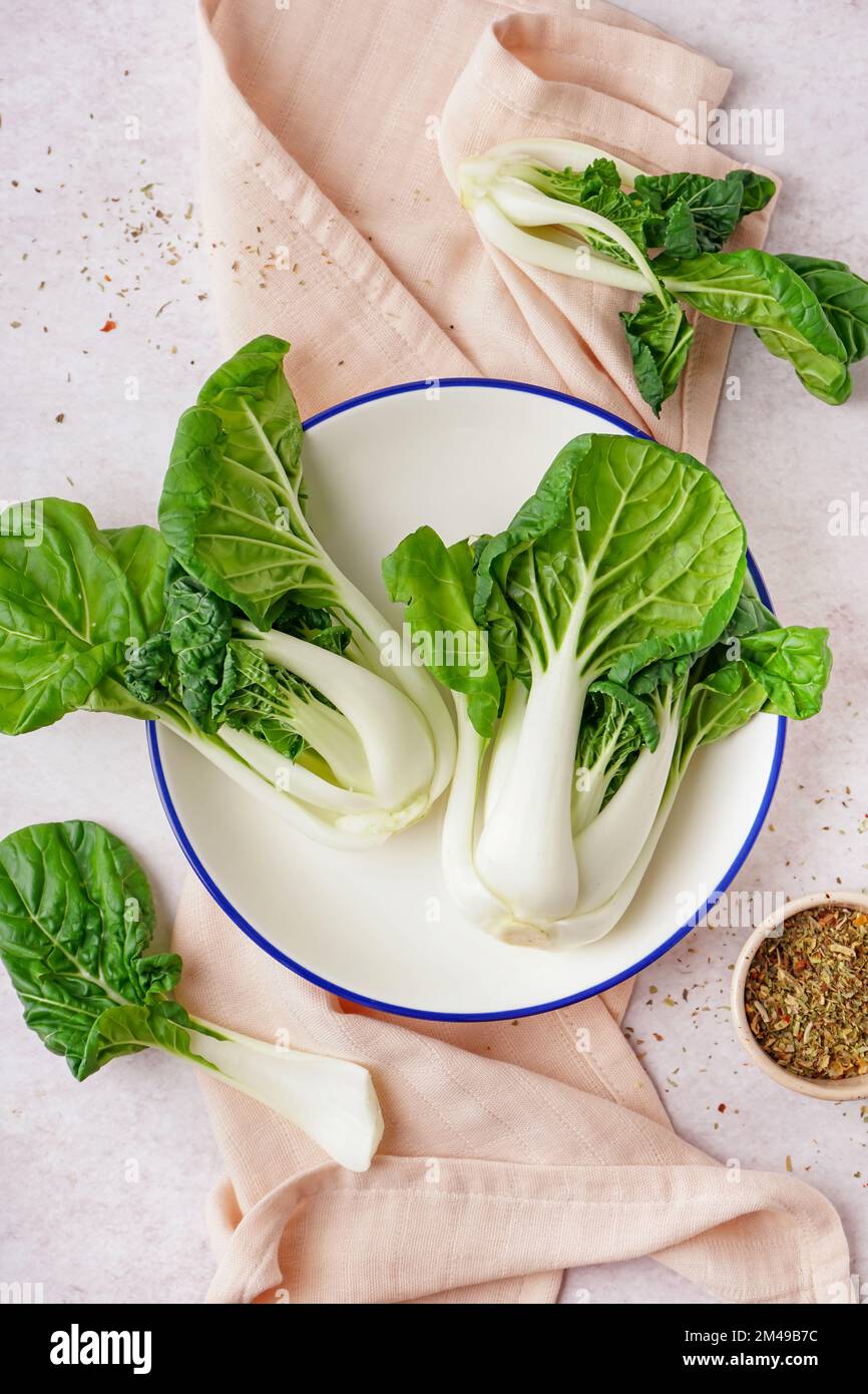 Plate of fresh pak choi cabbage on light background Stock Photo - Alamy