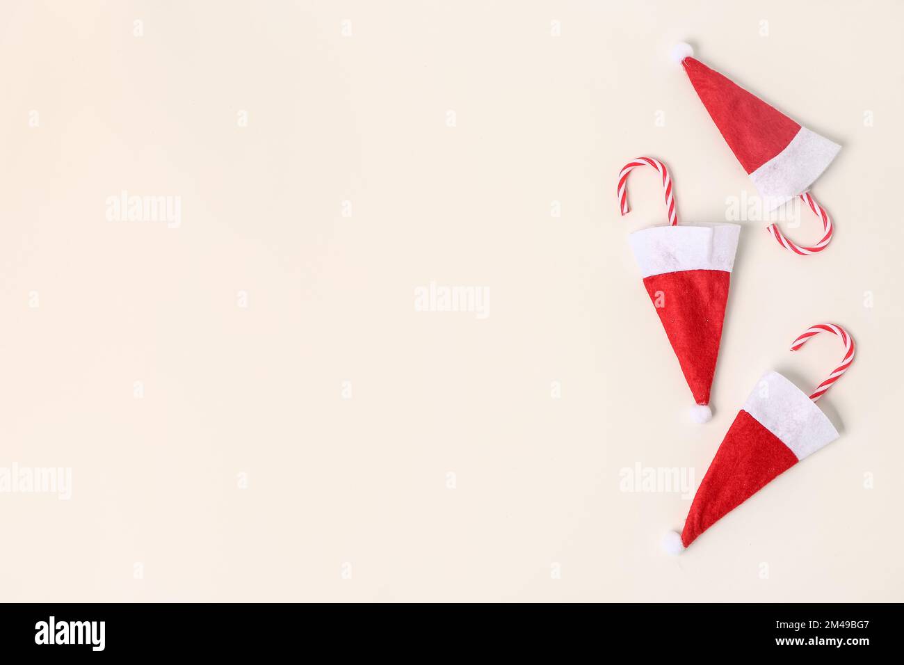 Santa hats with candy canes on light background Stock Photo - Alamy