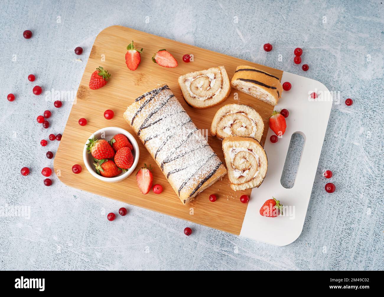 Cutting board with delicious sponge cake roll and fresh berries on ...