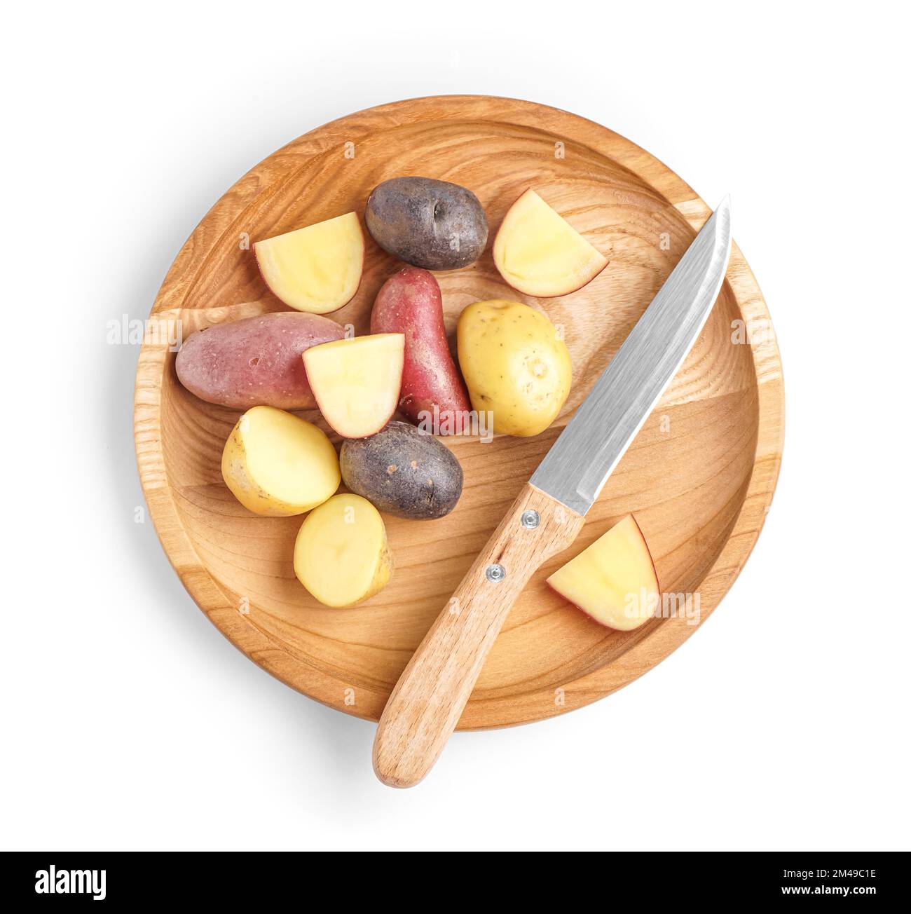 Wooden plate with different types of raw potatoes and knife on white ...