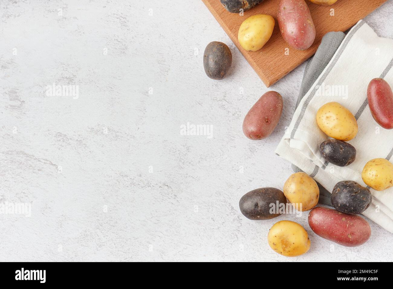 Different types of raw potatoes on light background Stock Photo - Alamy