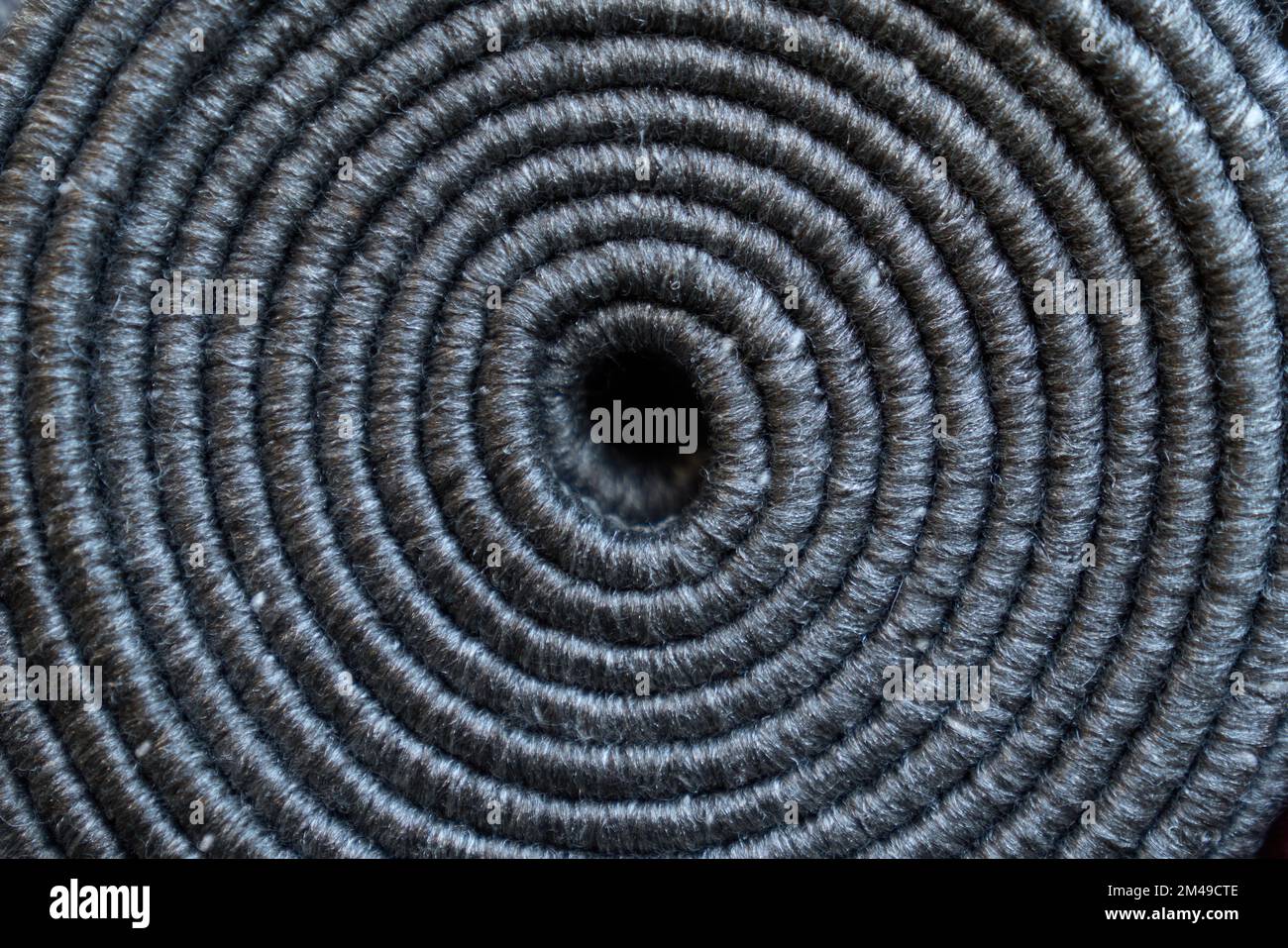 Relief texture of rolled up grey carpet as background. Close up of ...
