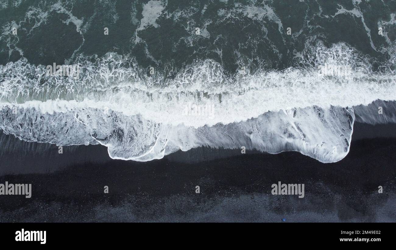 An aerial grayscale of big wave splash at the Reynisfjara Beach ...