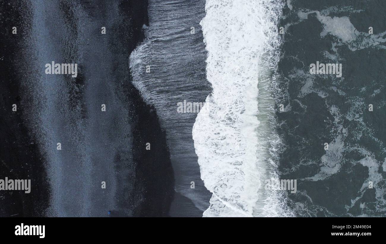 An aerial grayscale of a big wave splash at Reynisfjara Beach, Iceland ...