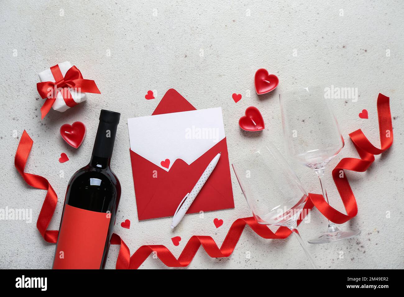Blank letter with bottle of wine, gift and hearts on white background ...