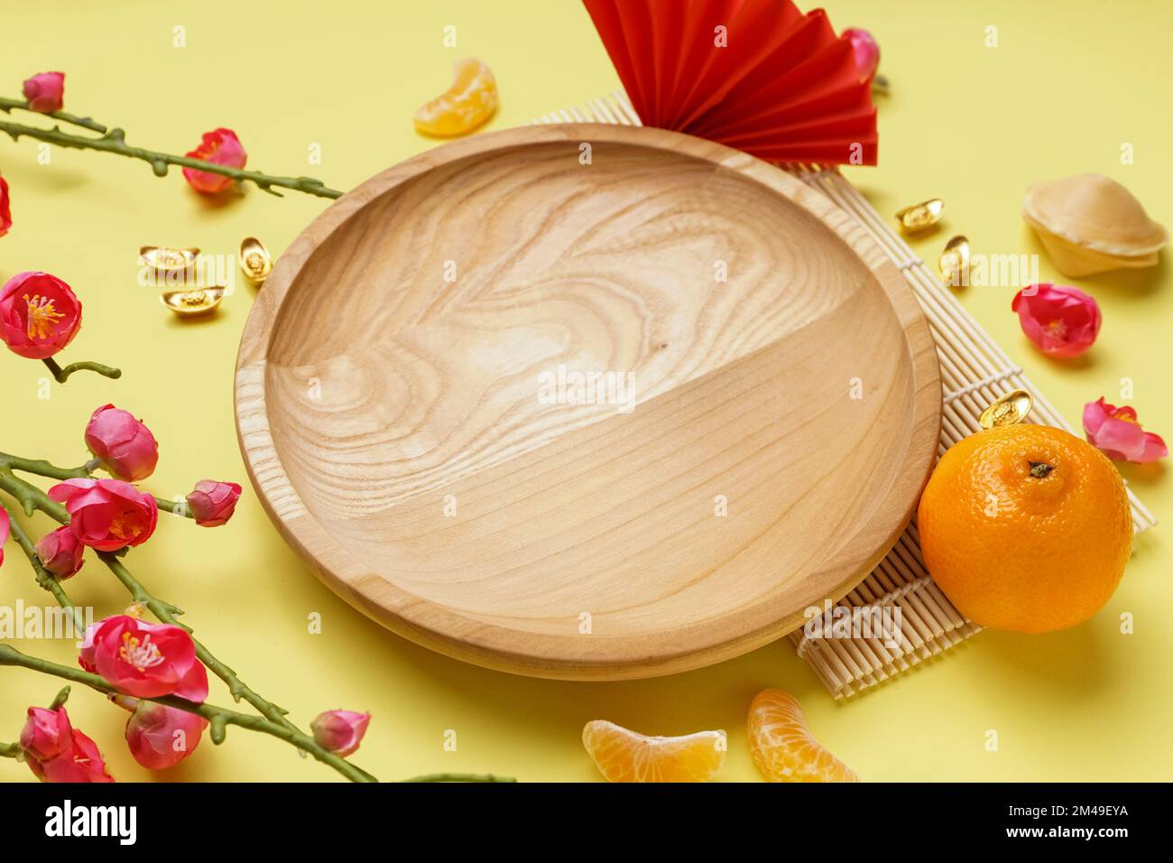 Wooden plate, mandarin and Chinese symbols on yellow background. New ...