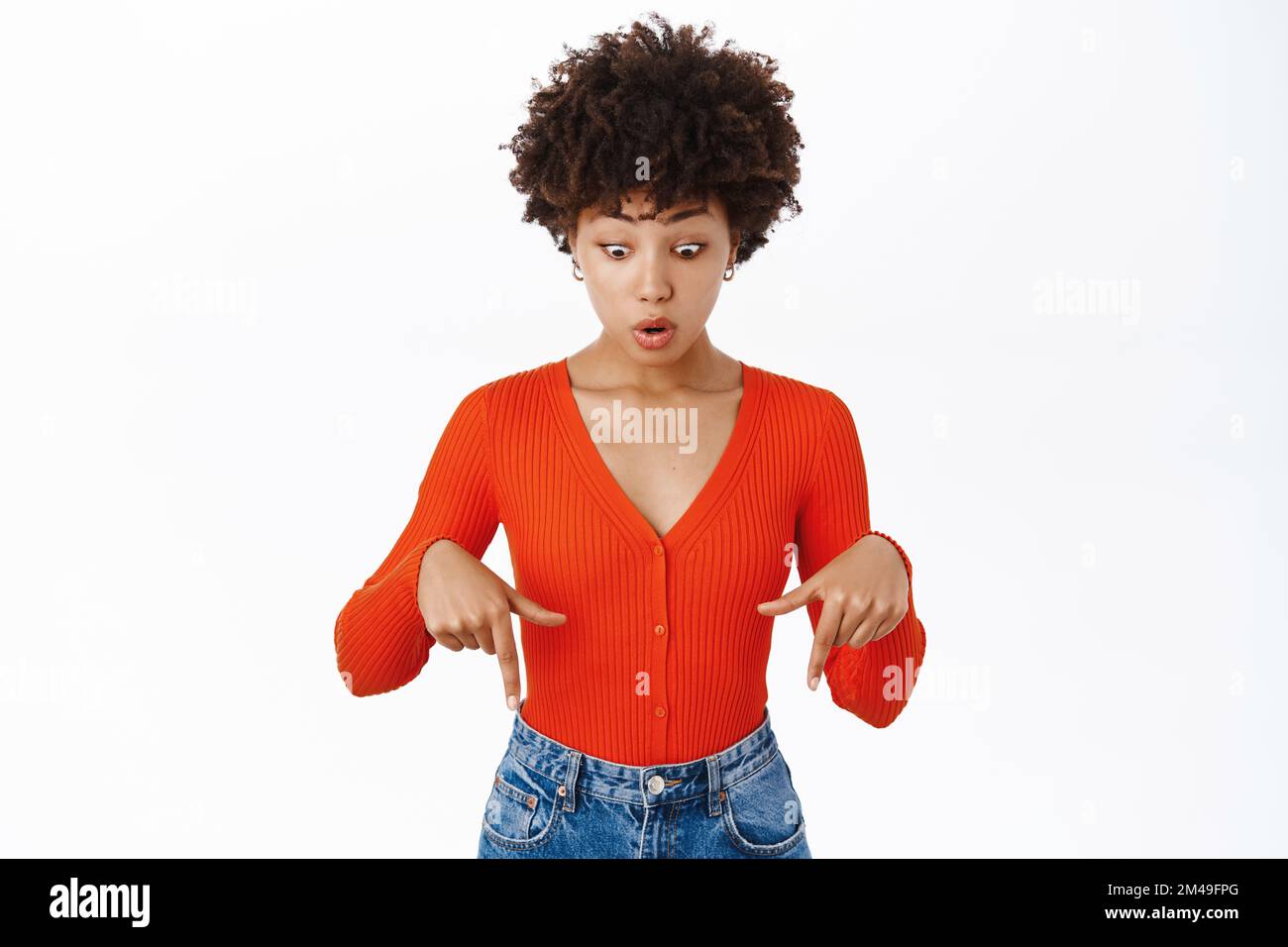 surprised african american woman, looking amazed below, pointing ...