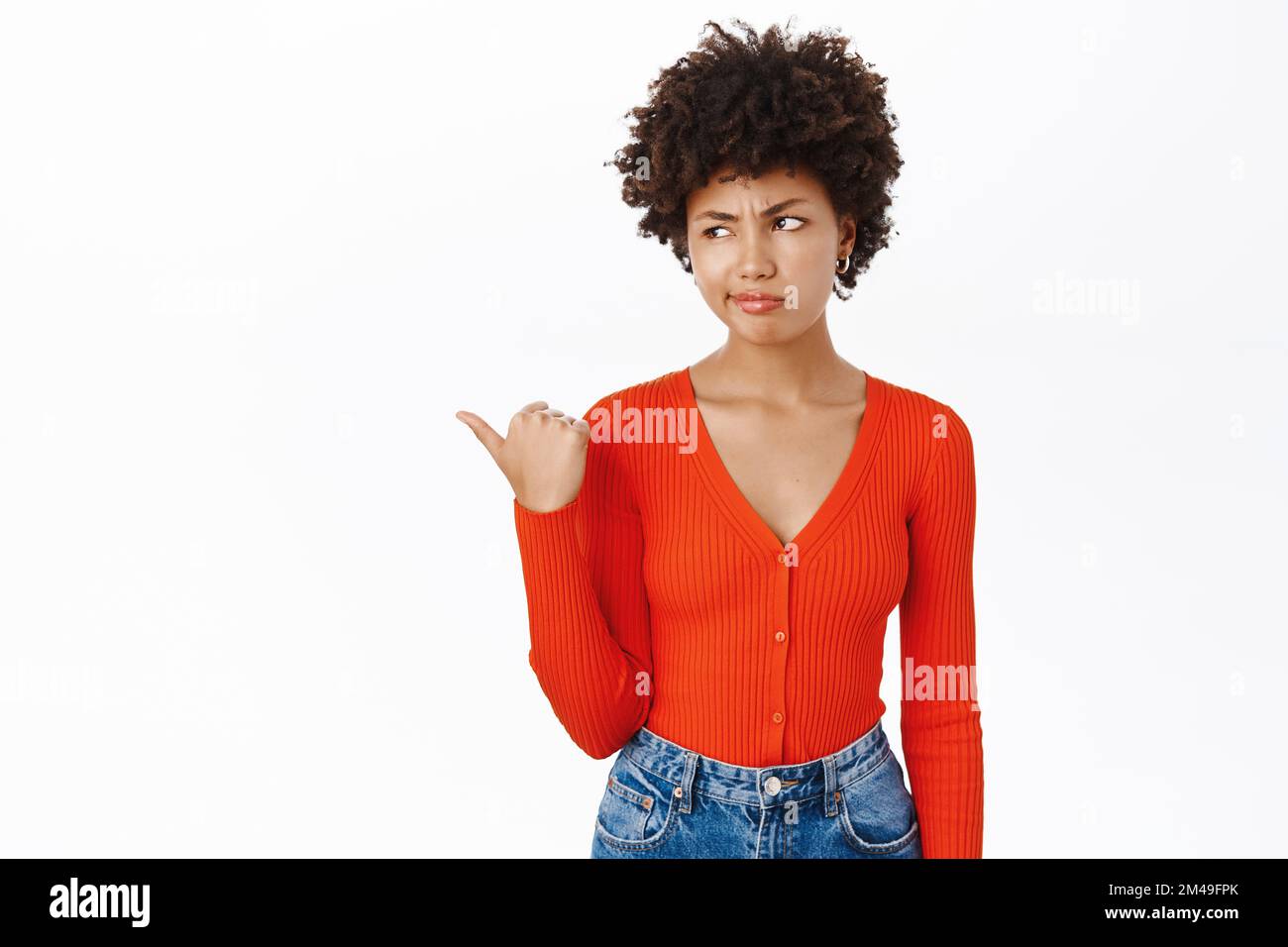 Beautiful girl with upset, disappointed face, pointing finger left ...