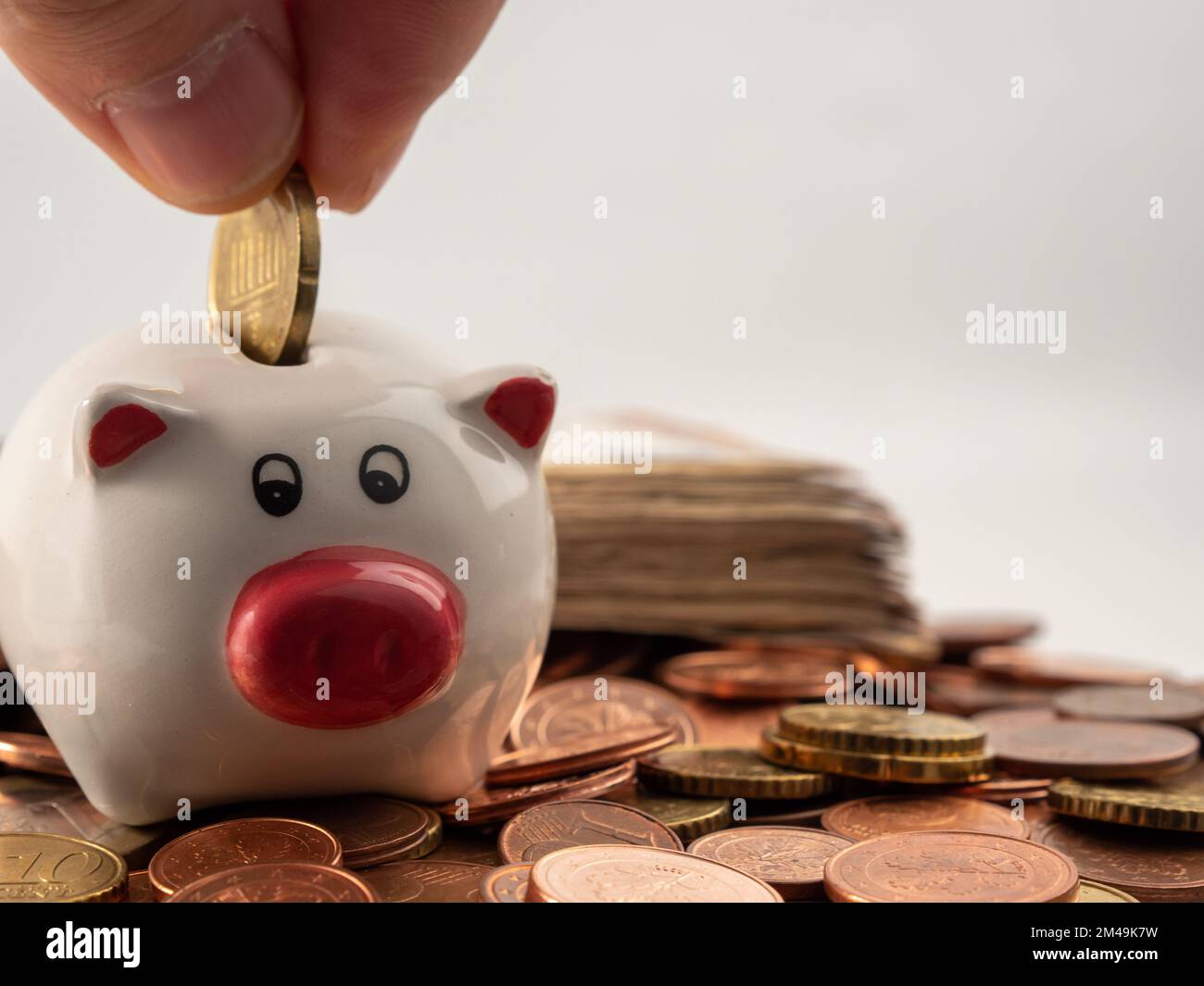 Throws a coin into the piggy bank. The hand throws a coin into the ...