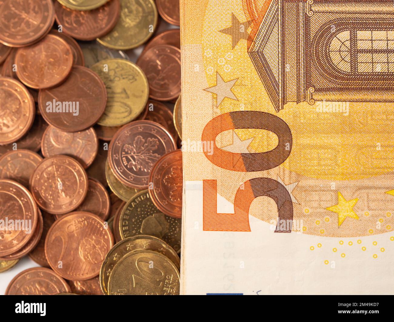 Metal coins and banknotes. A pile of euro cents and a stack of euro ...