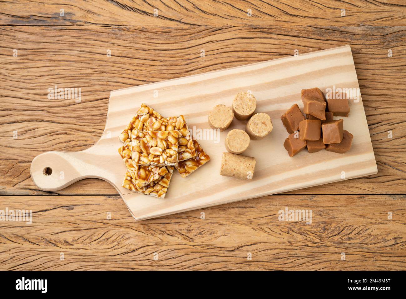 Typical brazilian candies over wooden board. Doce de leite or dulce de ...